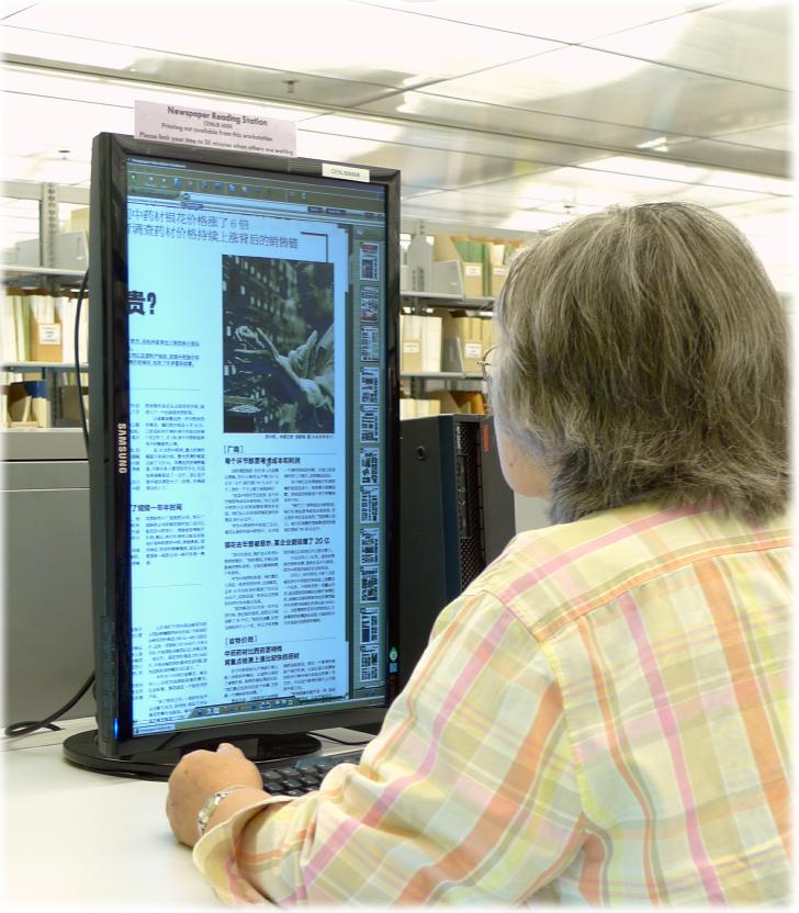 Patron reading newspapers on the new Newspaper Reading Stations – Shelf ...